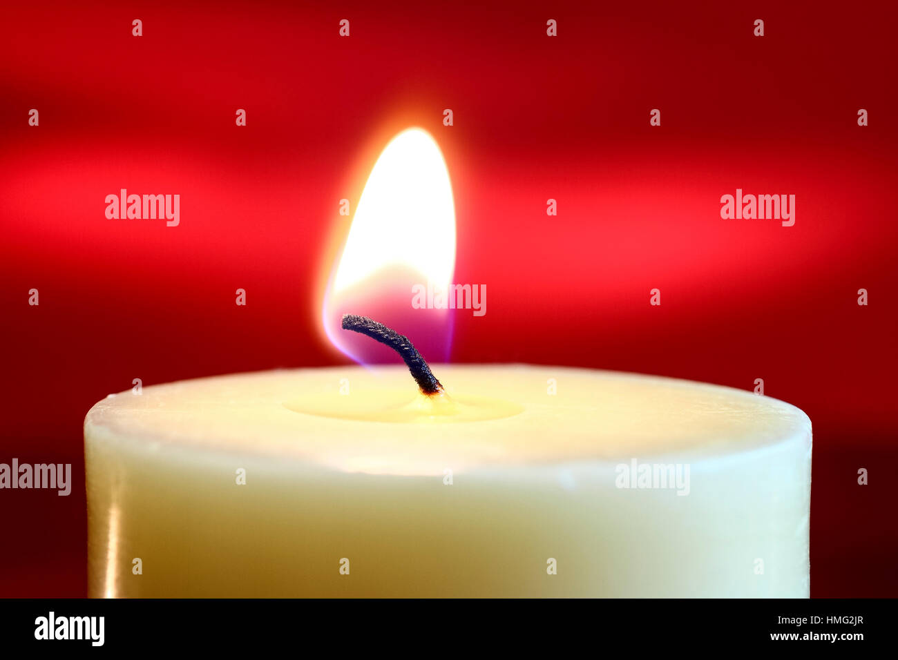 Flame of a burning wax candle isolated on a red background Stock Photo ...