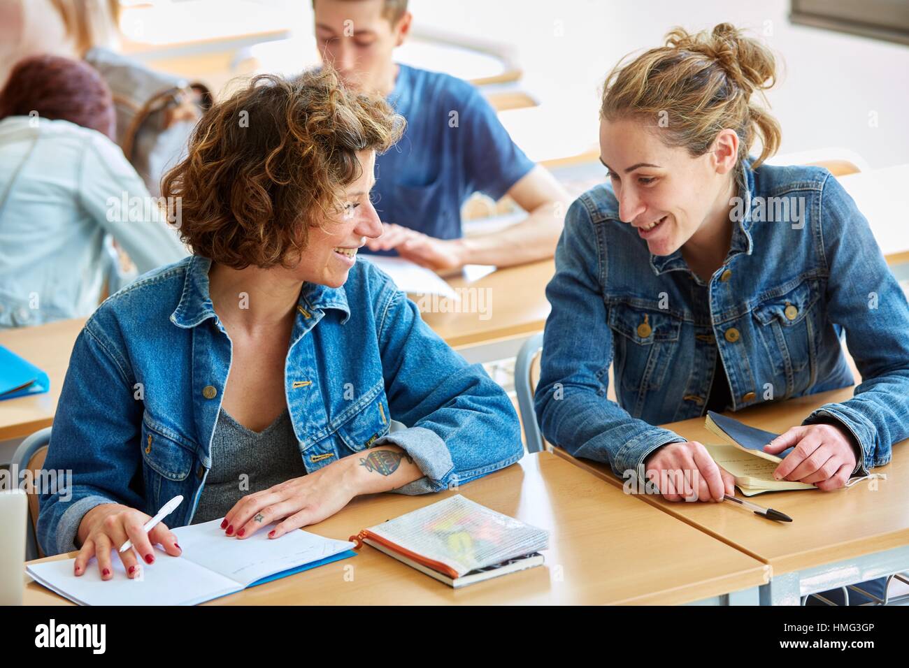 Students sitting at desk in classroom Stock Photo - Alamy