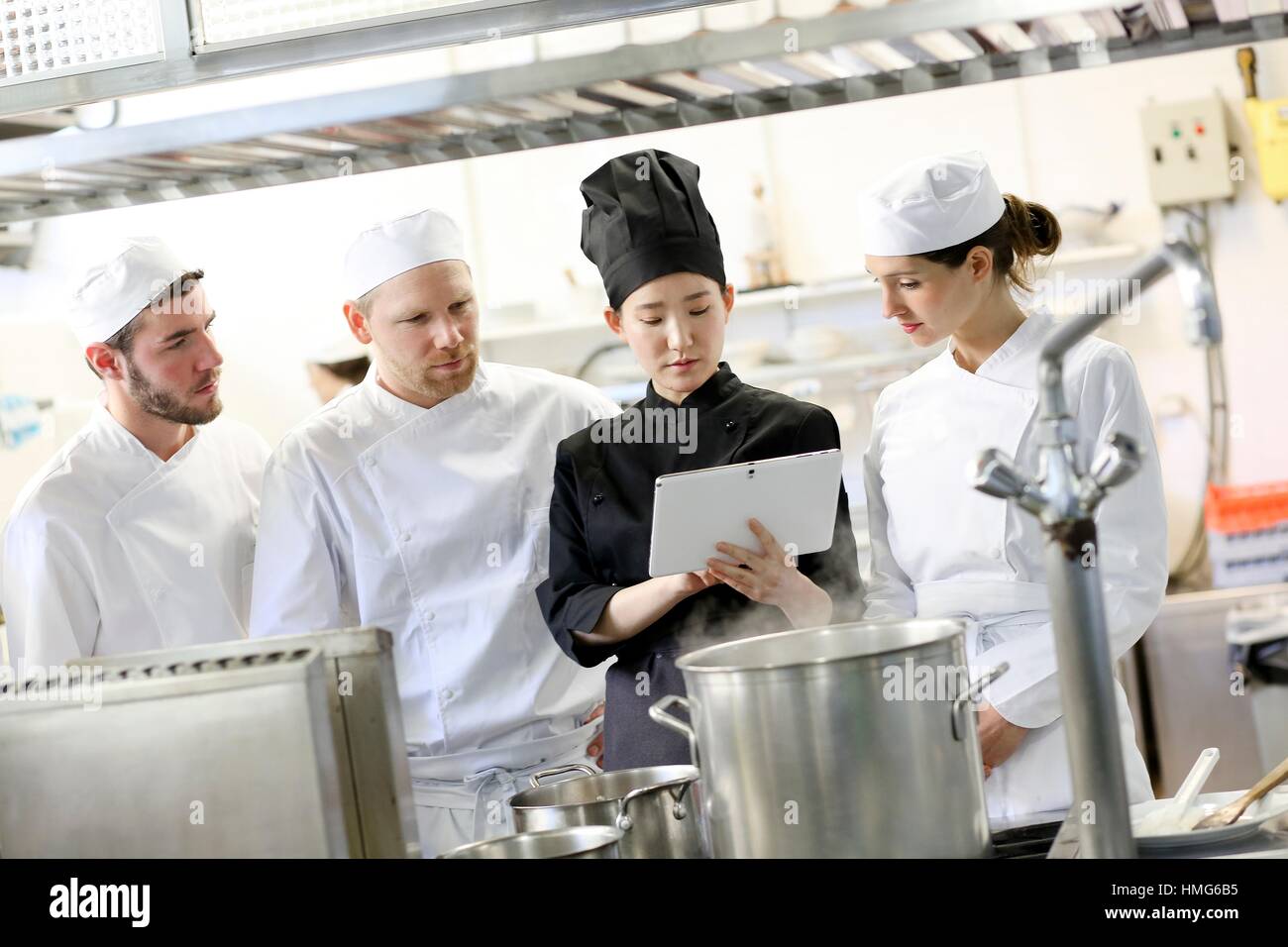 Chefs preparing menu in restaurant kitchen Stock Photo - Alamy
