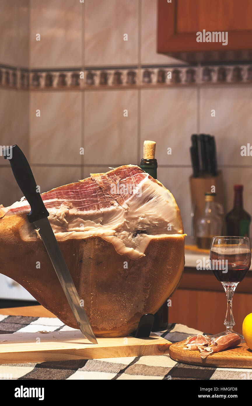 Spanish Jamon Serrano on wooden tabla jamonera with knife, apple, glass ...