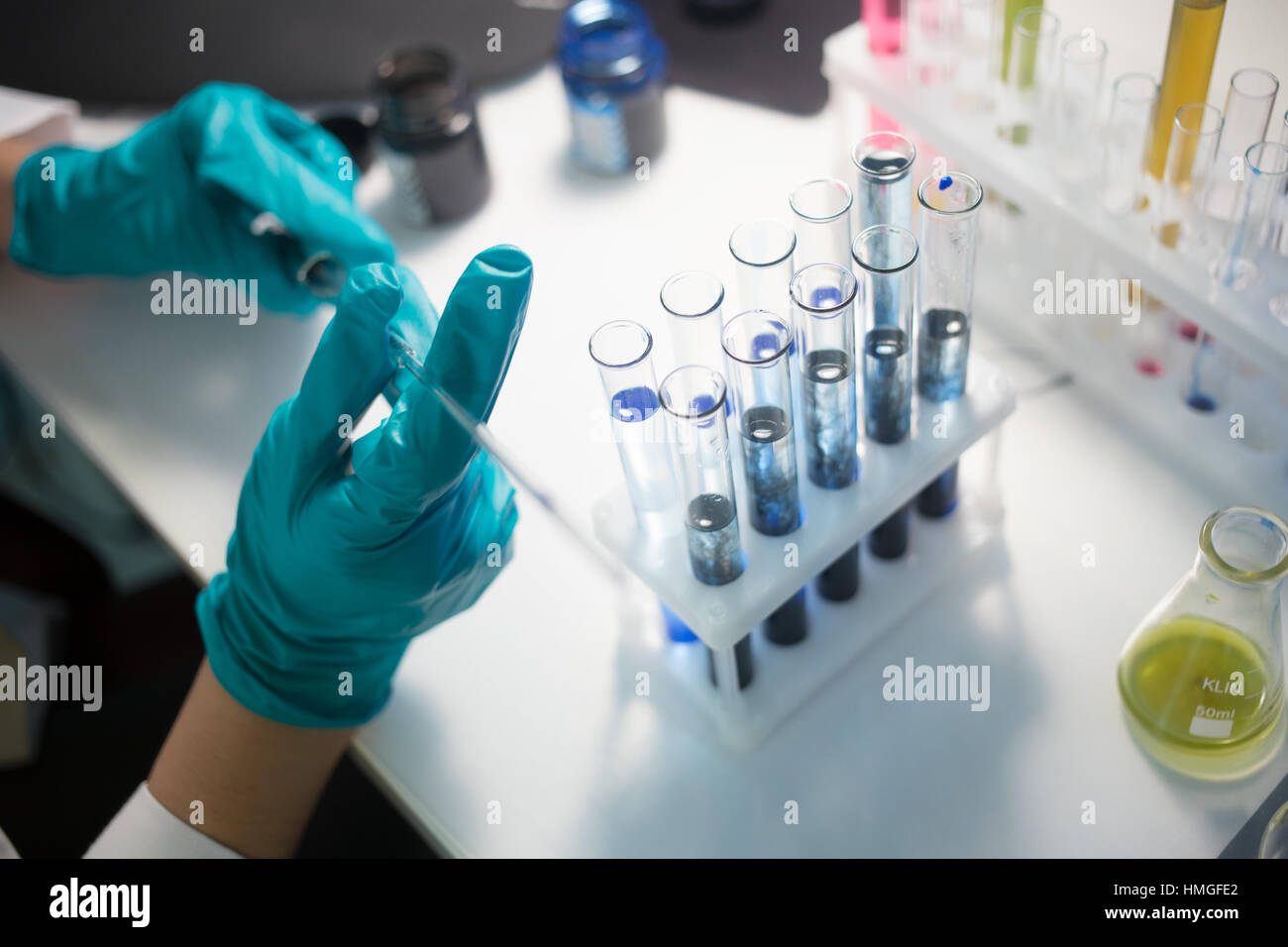 Lab technician carries chemical experiments sitting at table with test ...