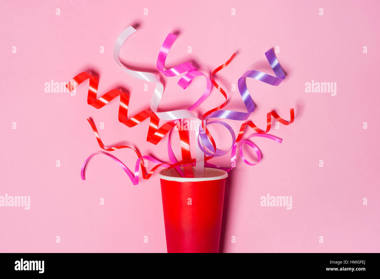 Flat lay of Celebration. Paper cup with colorful party streamers on ...