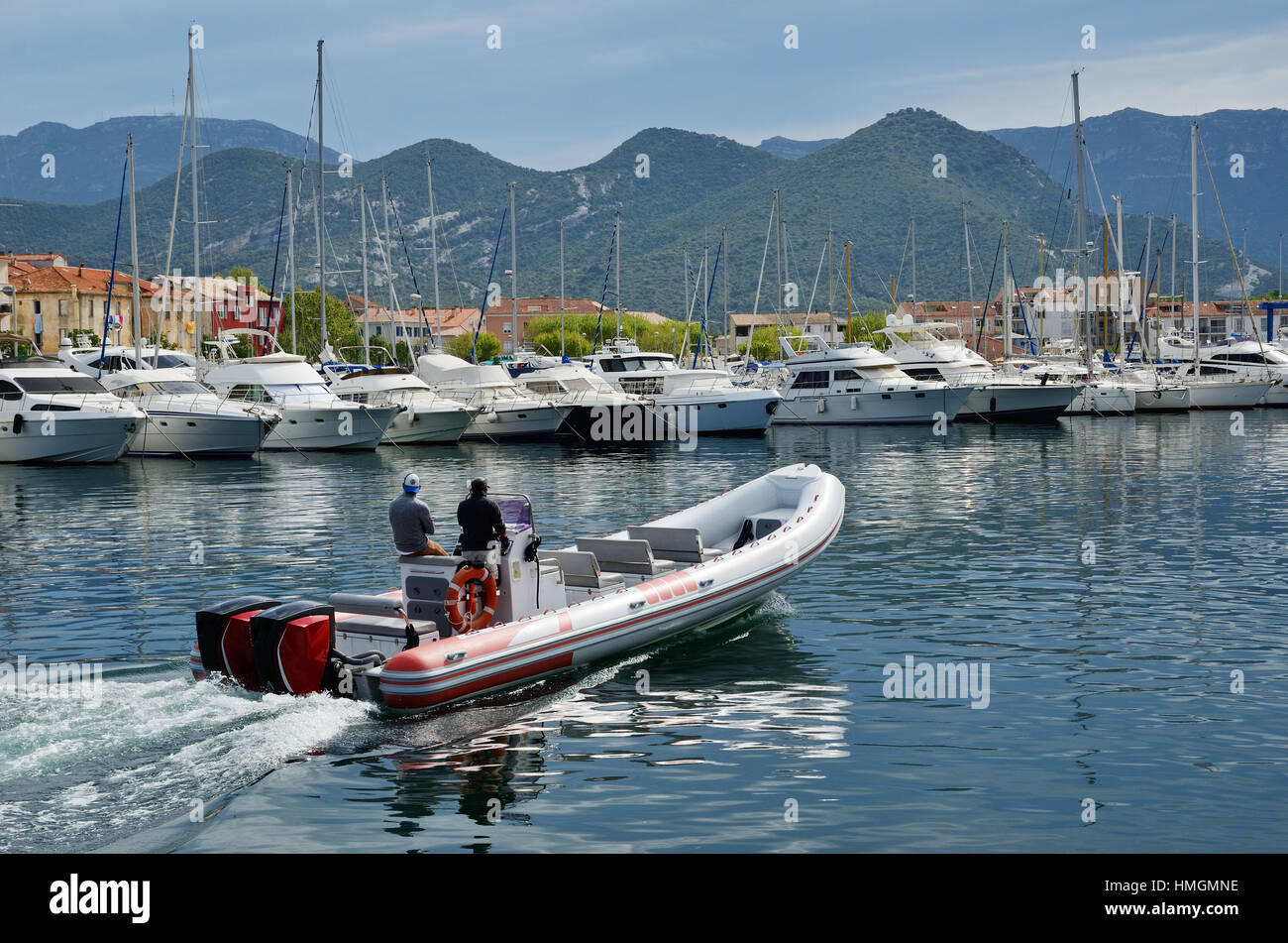 A pleasure-boat is floating along the berth with many modern vessels in ...