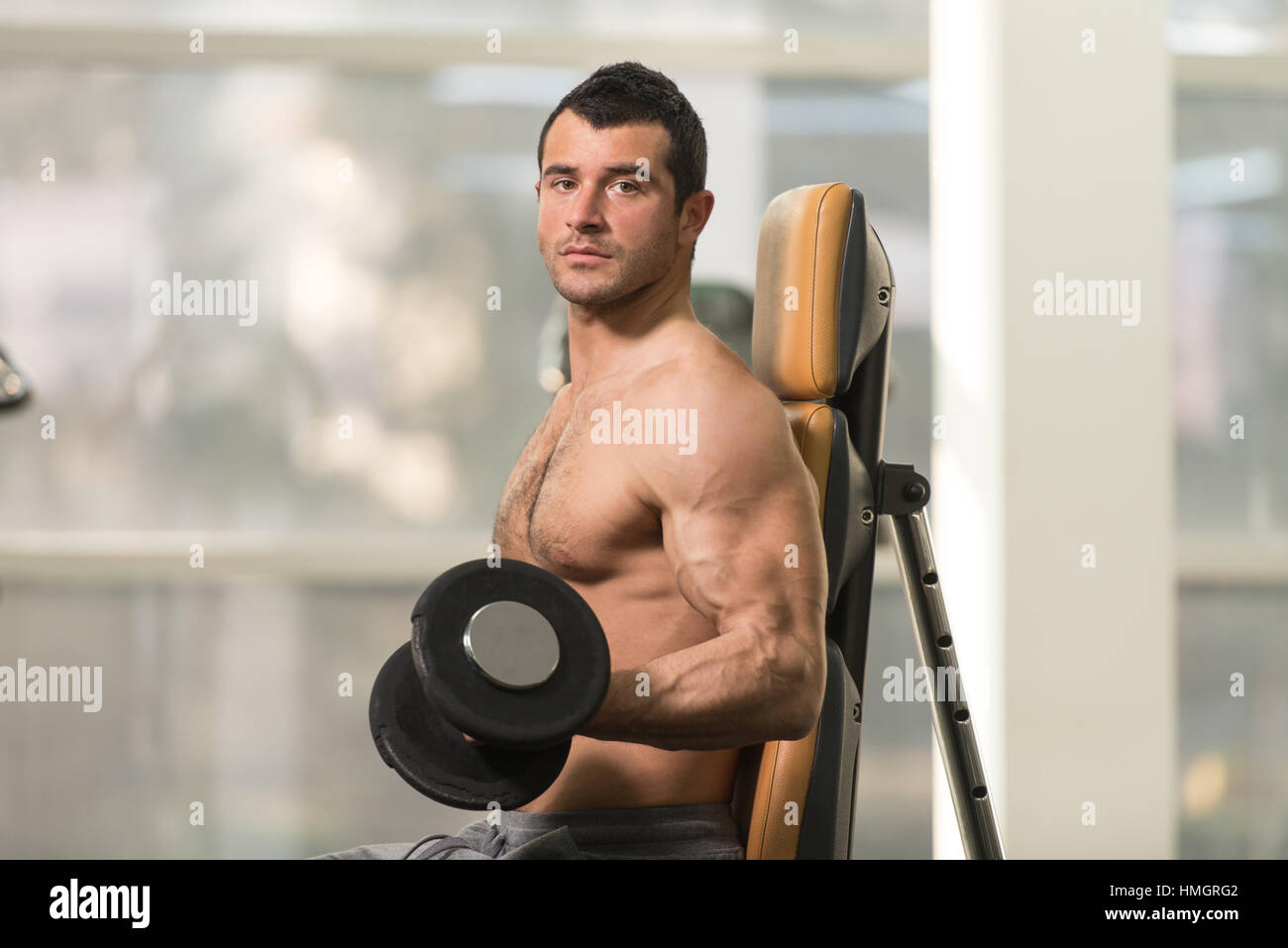 Handsome Hairy Man Working Out Biceps In A Fitness Center Gym ...