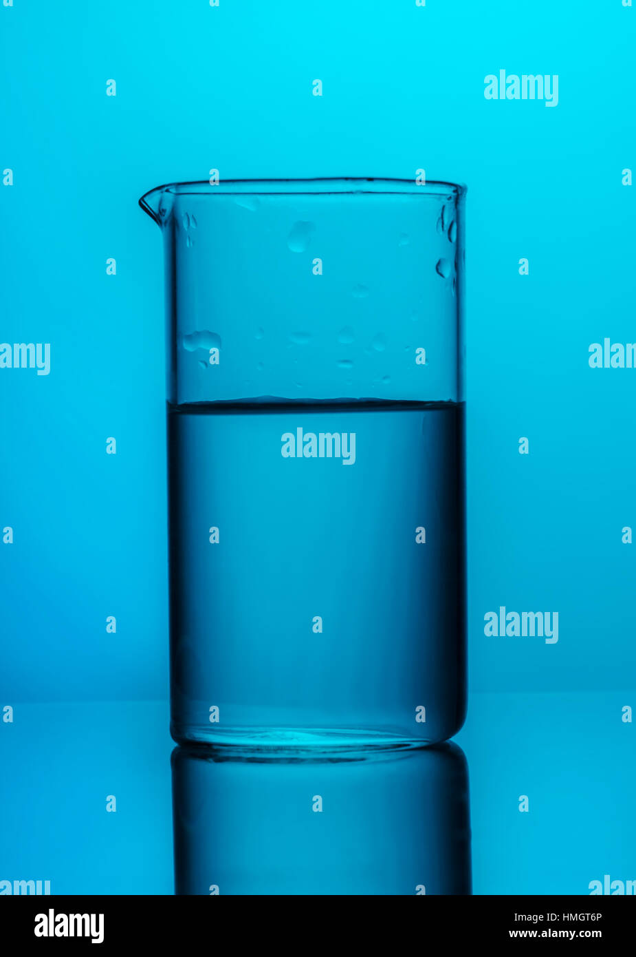 Chemical flask with liquid on blue background Stock Photo - Alamy