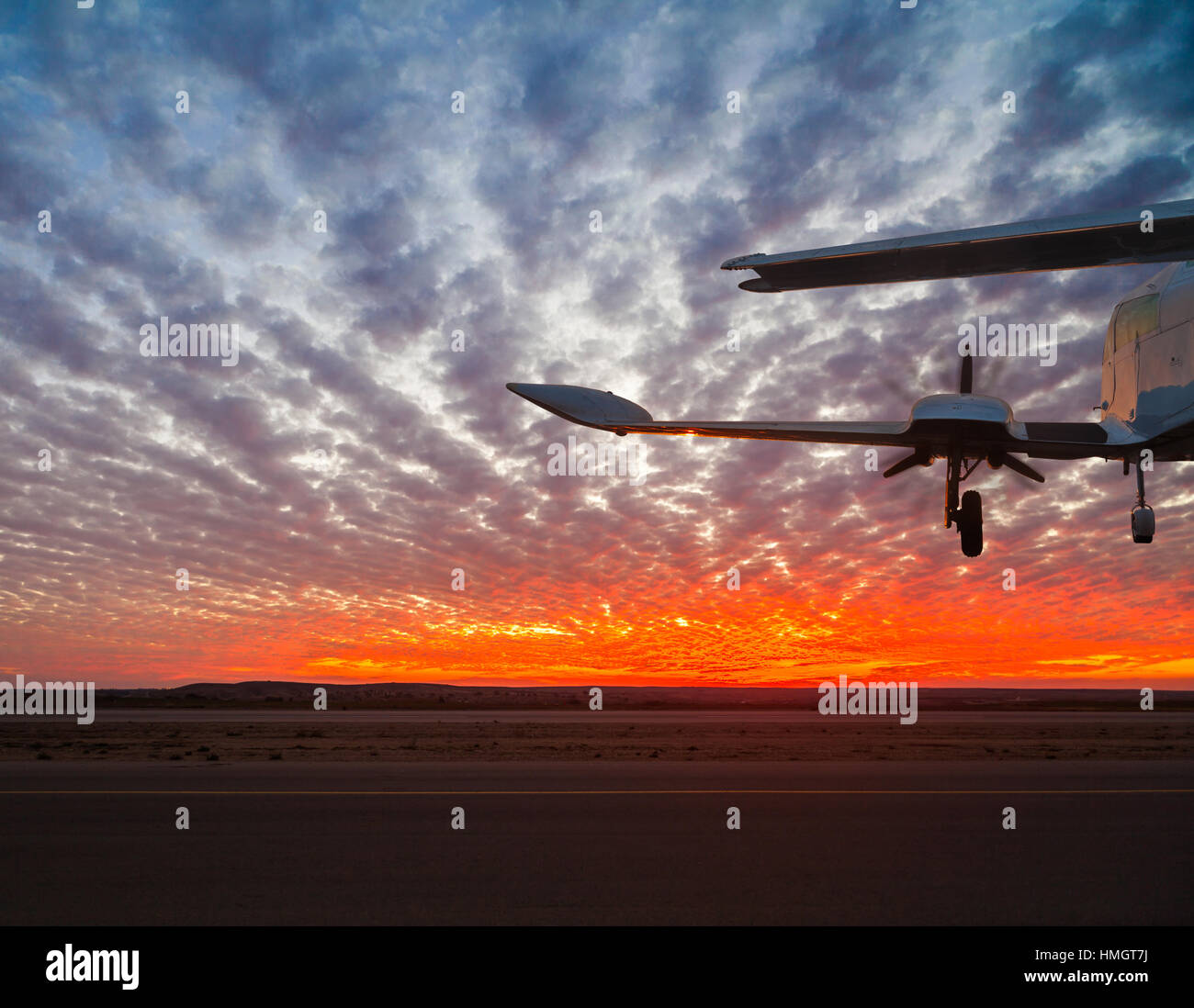 small plane on the runway at sunset background Stock Photo - Alamy