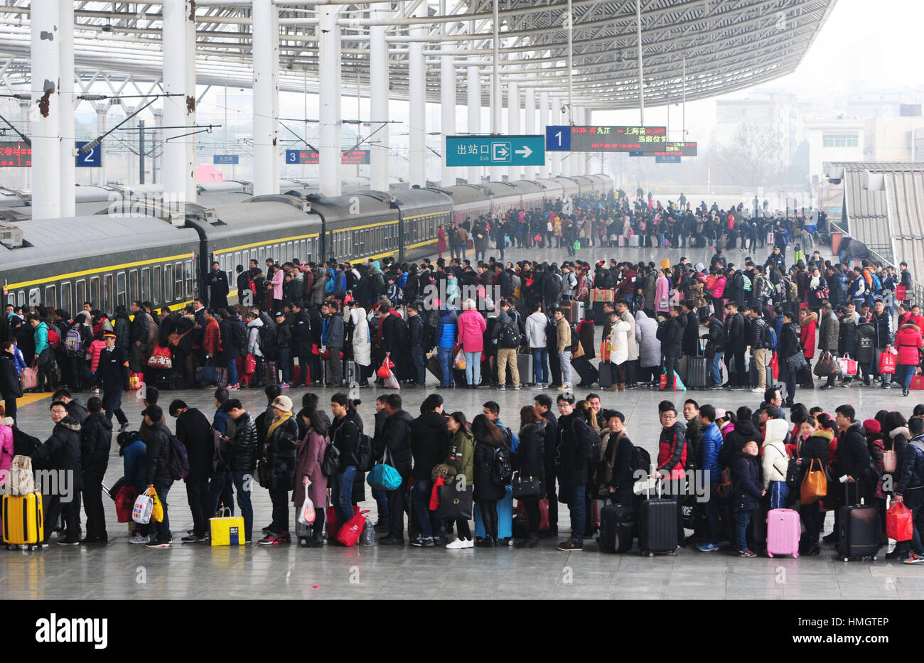 Jiujiang, China. 2nd Feb, 2017. Passengers queue up to board a train at ...