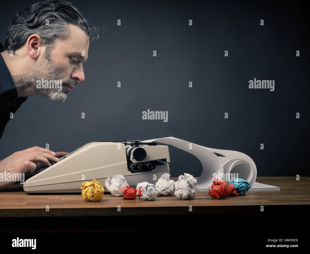 Editor with his typewriter and many crumpled paper, creativity concept ...