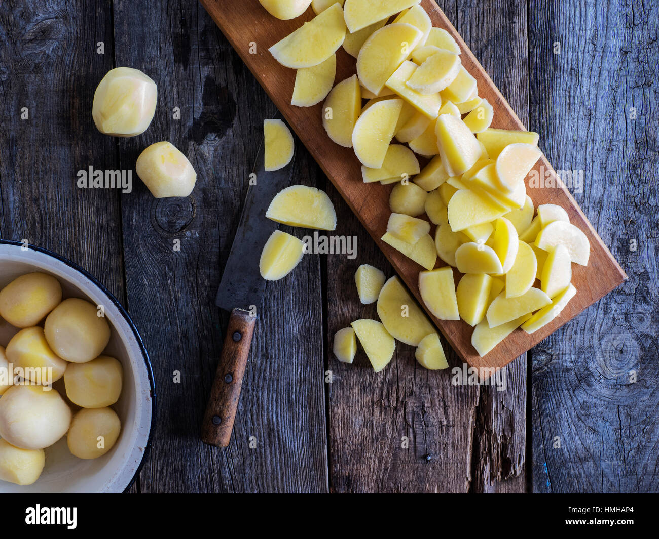 Raw peeled and sliced potatoes on an old weathered wooden table Stock ...