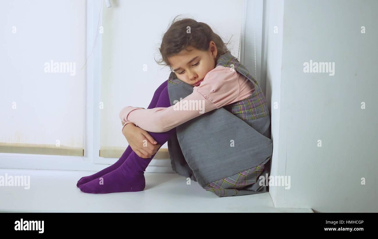 sad young teen girl sitting by the window, looking out the window Stock ...