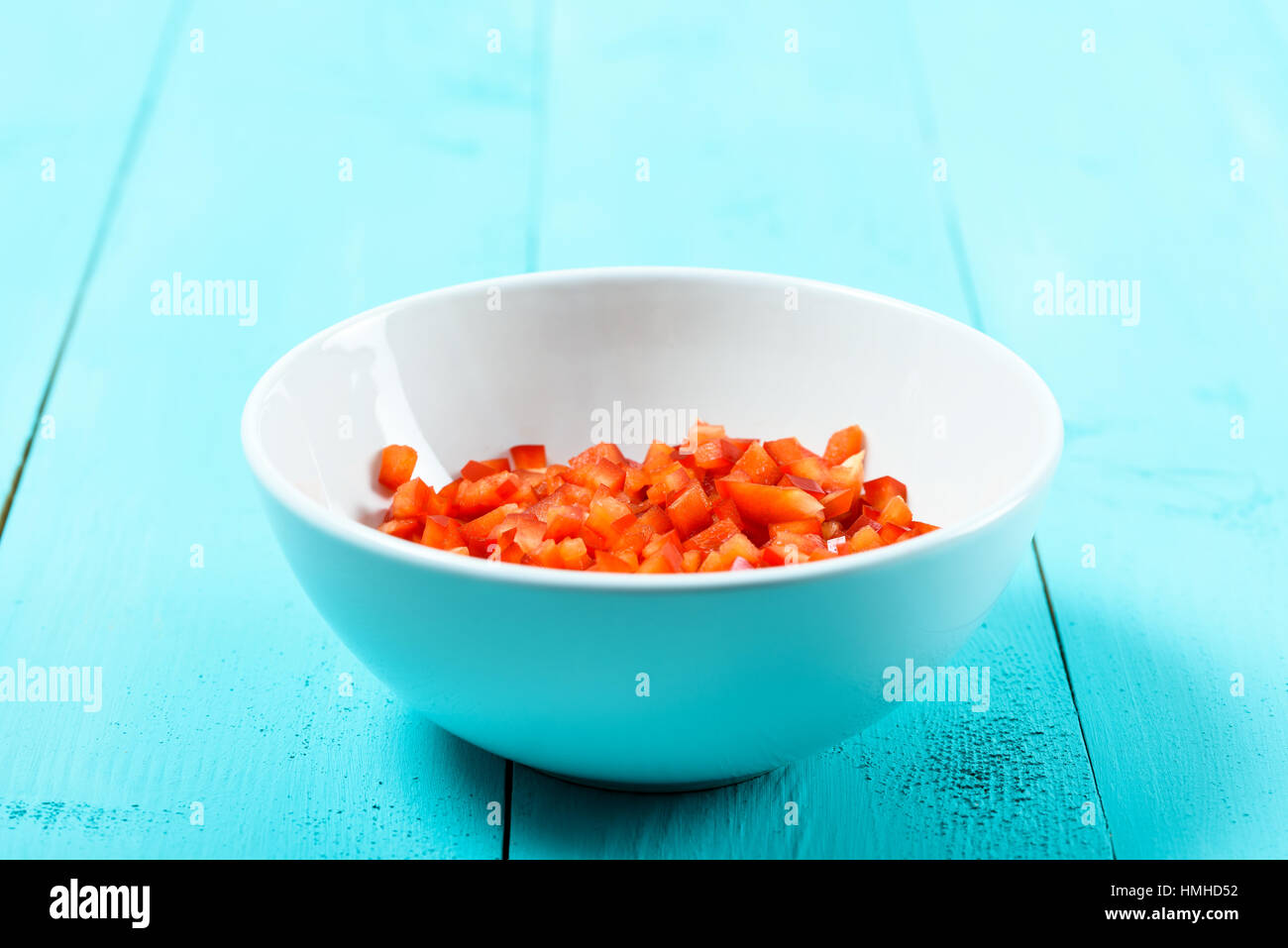 Chopped Red Capsicum In White Bowl On Turquoise Table Stock Photo - Alamy