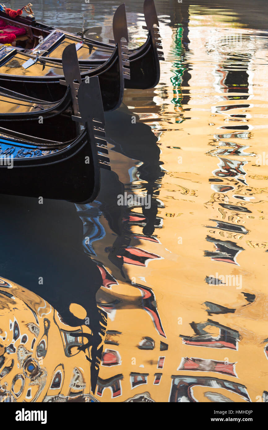 Gondolas detail in golden sunlight with building reflections in water ...
