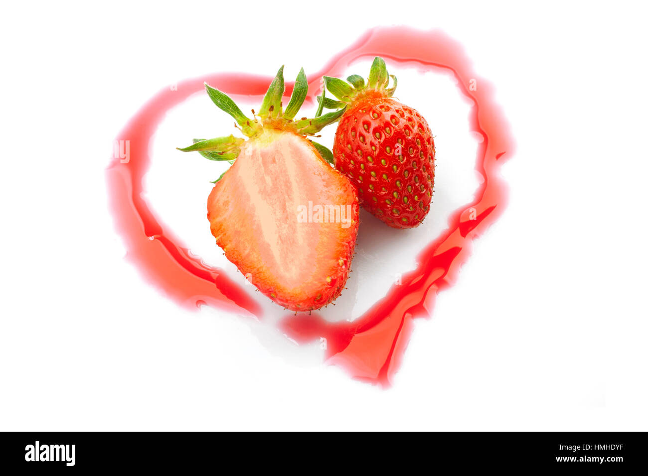 closeup studio photo of two strawberries one half cut inside shinny ...