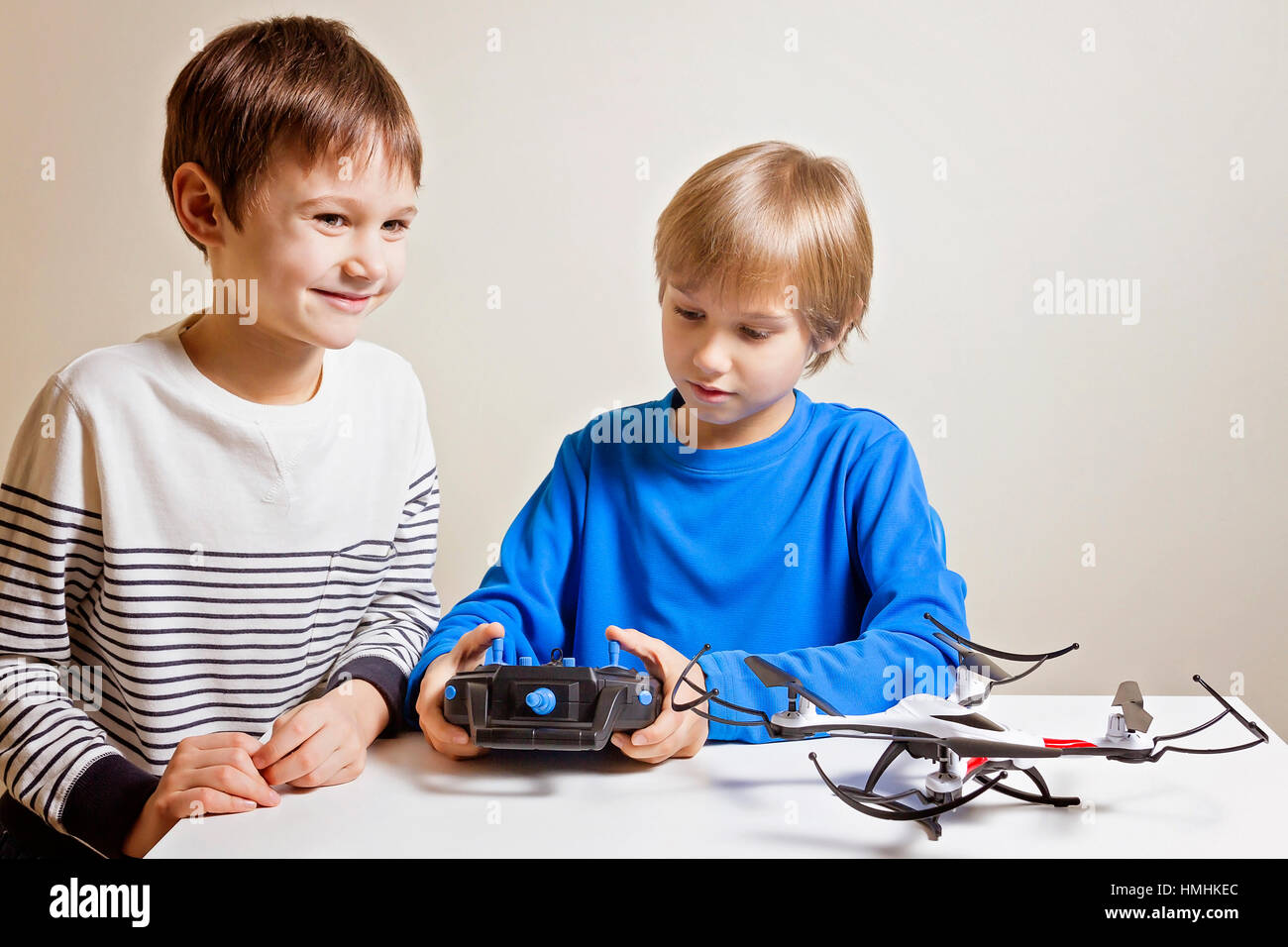 Kids playing with drone at home. One boy holding a radio remote control ...