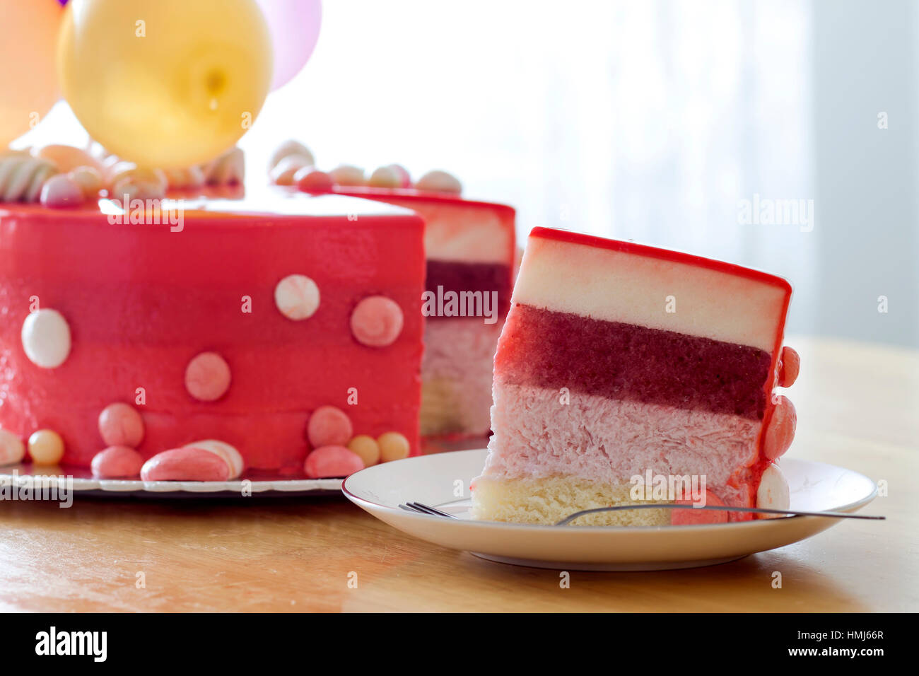 Homemade red birthday cake with air baloons. Slice of a red velvet cake ...