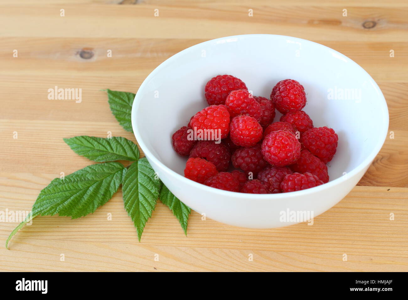 red raspberry fruits in a small white bowl Stock Photo - Alamy
