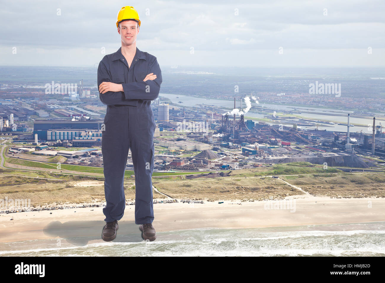 Giant young worker with steel factory on background Stock Photo - Alamy