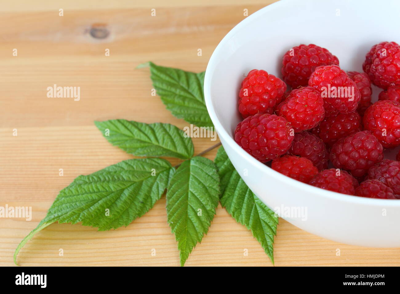 red raspberry fruits in a small white bowl Stock Photo - Alamy