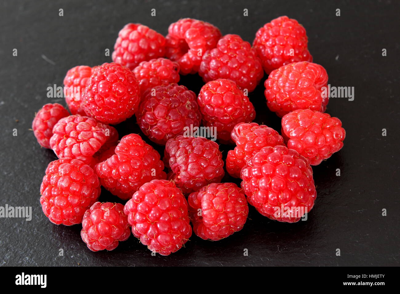 red raspberry fruits on a slate plate Stock Photo - Alamy
