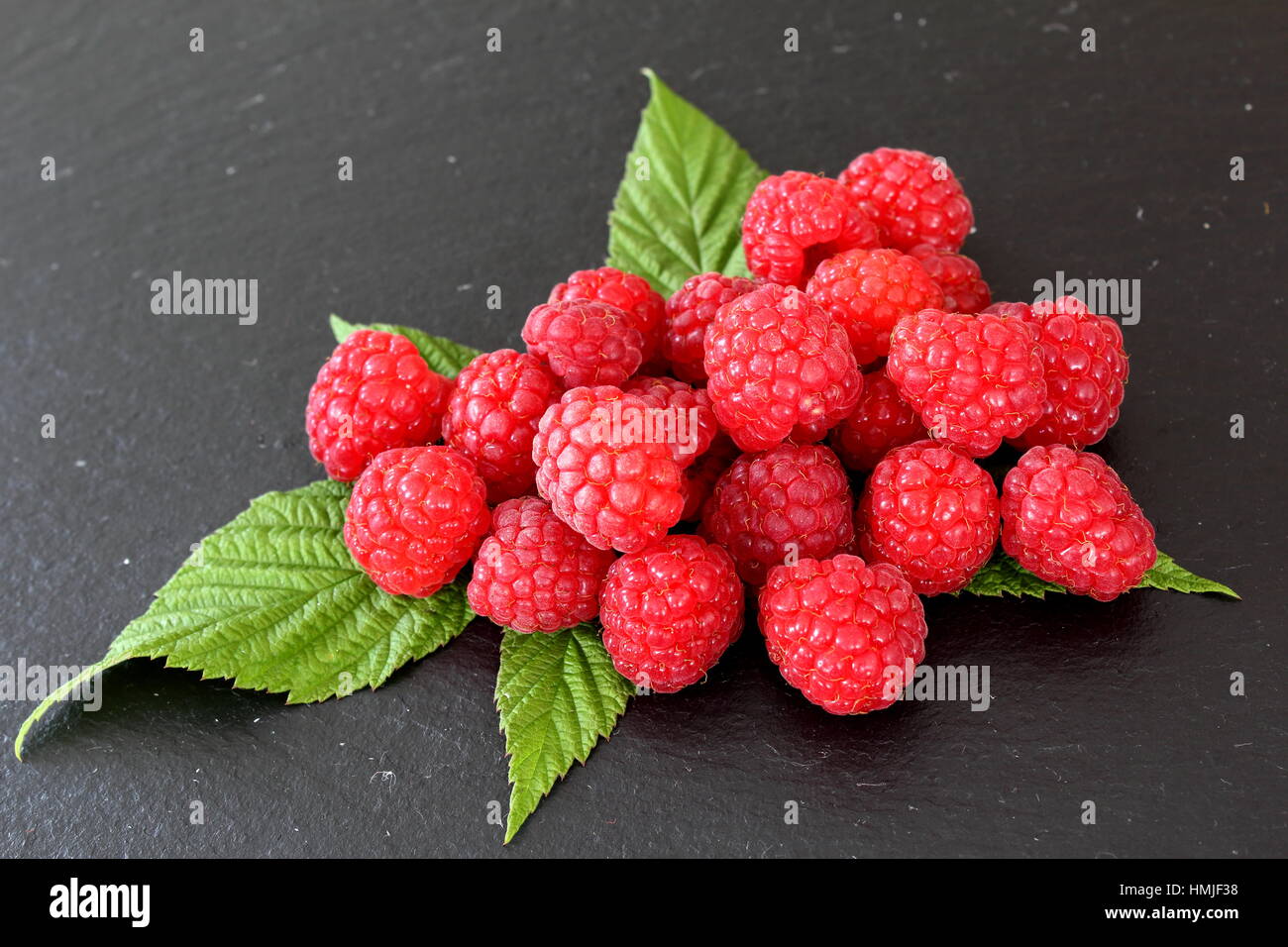 red raspberry fruits on a slate plate Stock Photo - Alamy