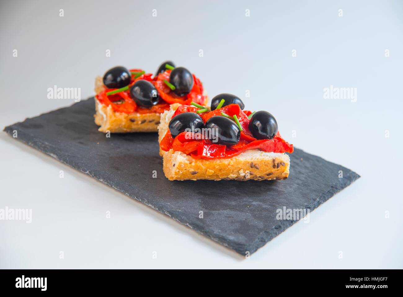 Spanish tapa: red peppers and black olives with cheese cream and chives ...