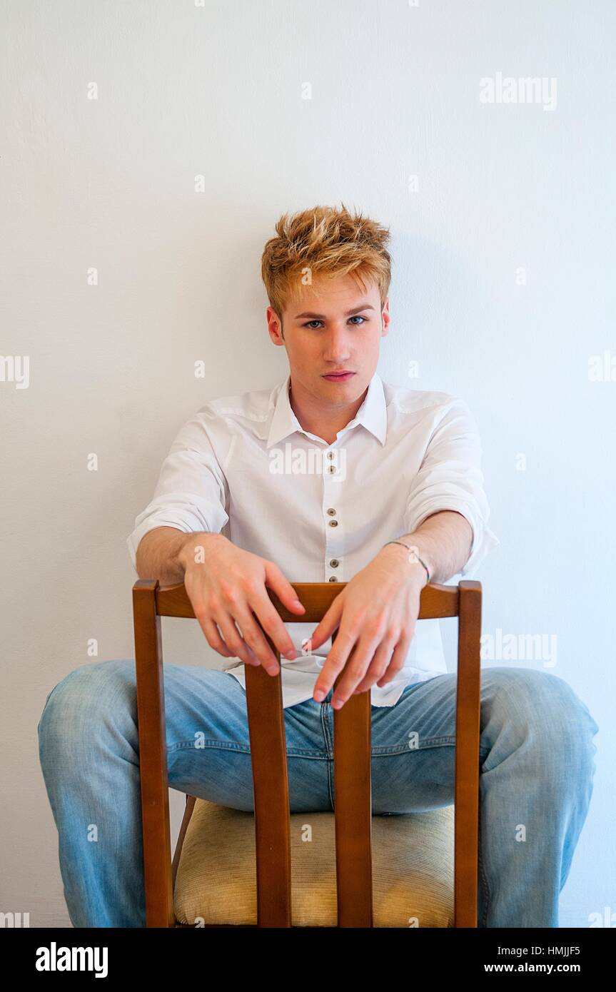 Young man sitting astride on chair hi-res stock photography and images ...