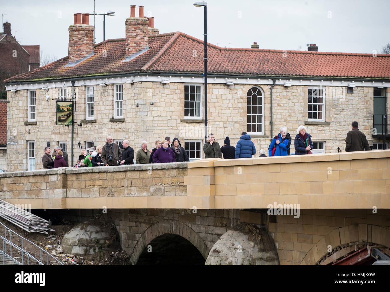 Members of the public stand on Tadcaster Bridge as it reopens more than ...