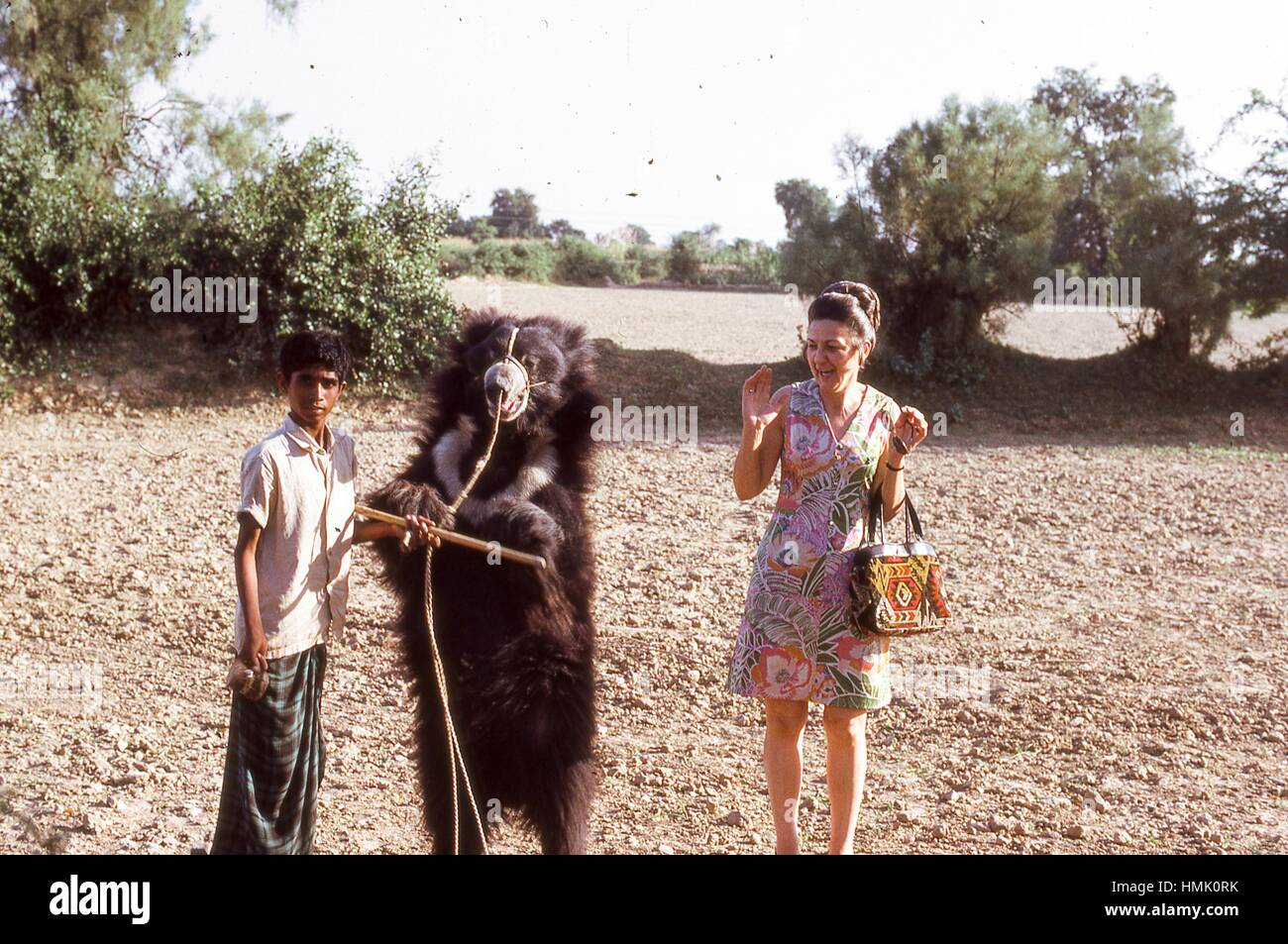 Scene of a Western woman hesitantly posing with a young Indian boy and ...
