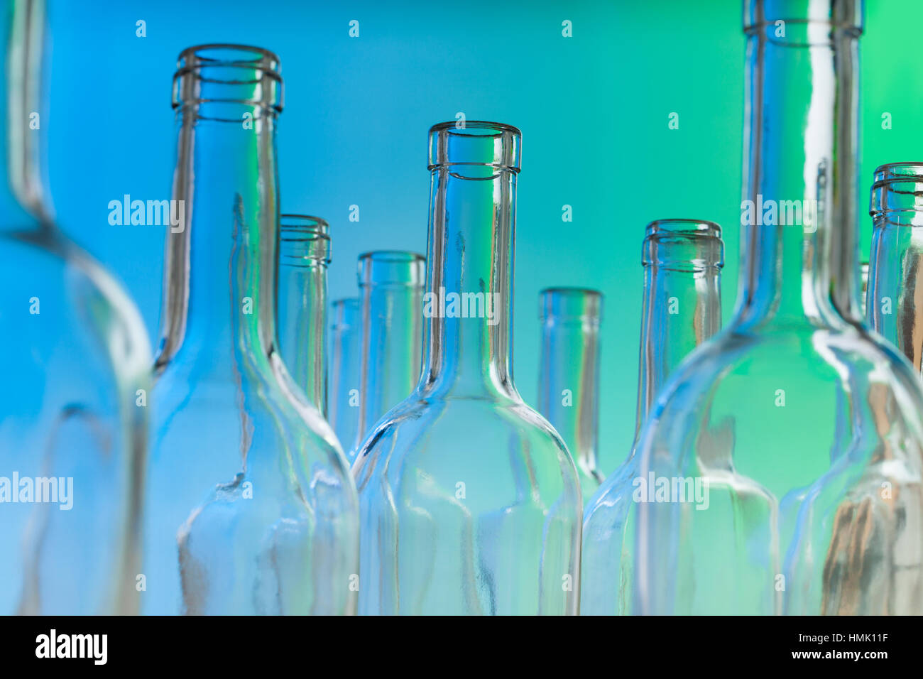 Glass wine bottlenecks on blue background Stock Photo - Alamy