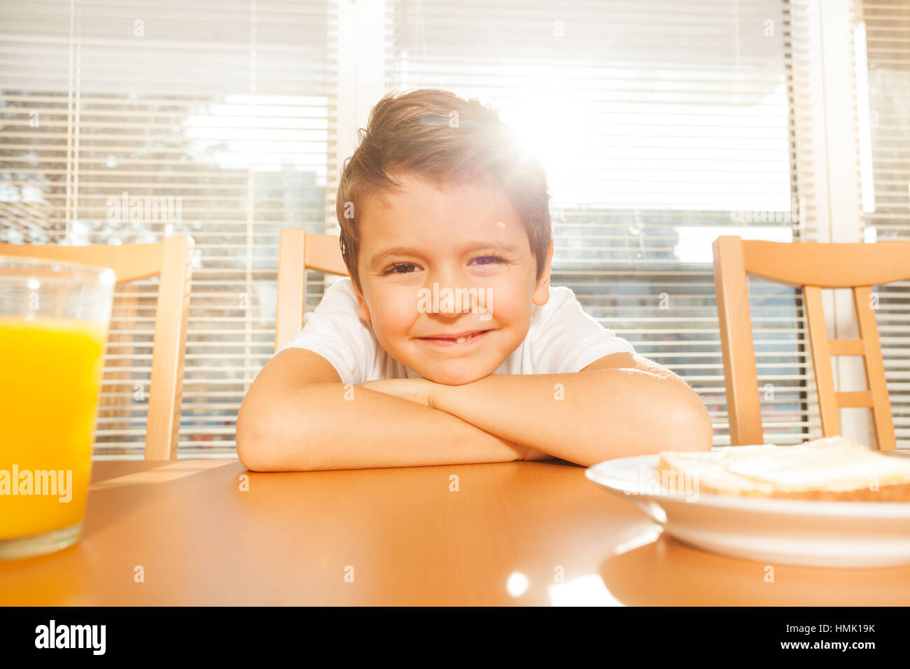 Cute boy sitting at the table with his breakfast Stock Photo - Alamy