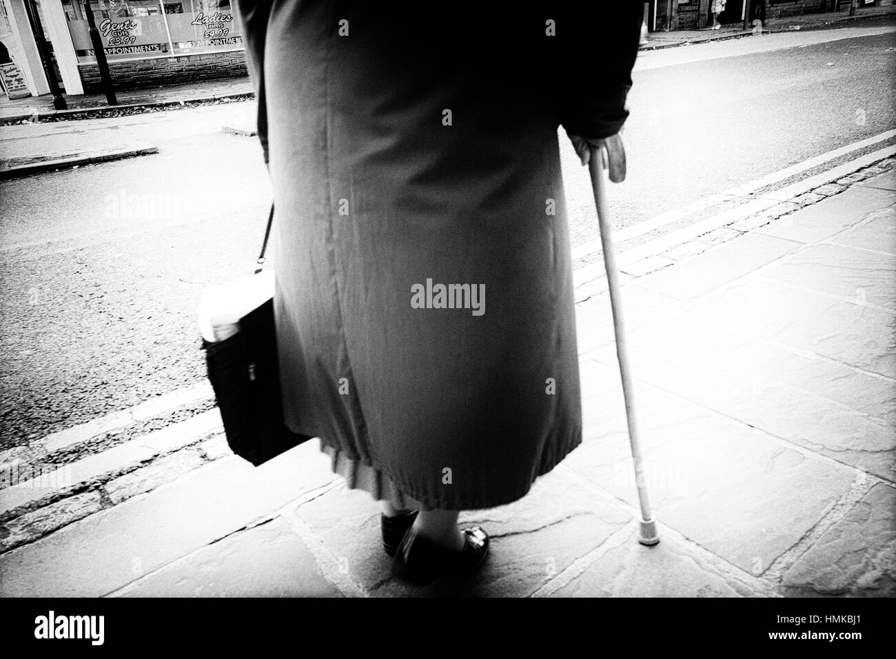 Unrecognizable old lady with coat and bag in hand, walking down the ...