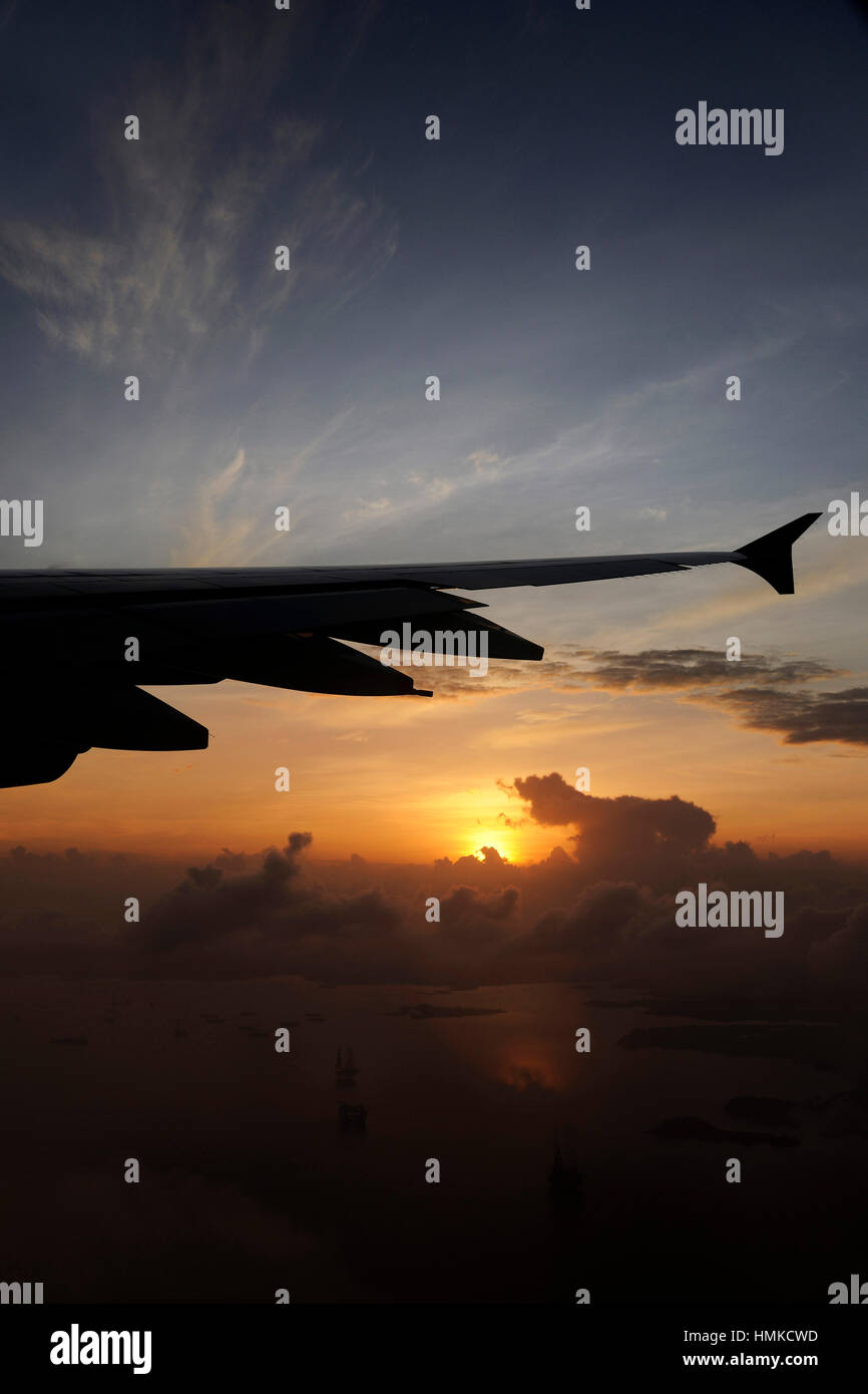 sunrise over Straits Singapore, wing winglet Airbus A380 flying enroute ...
