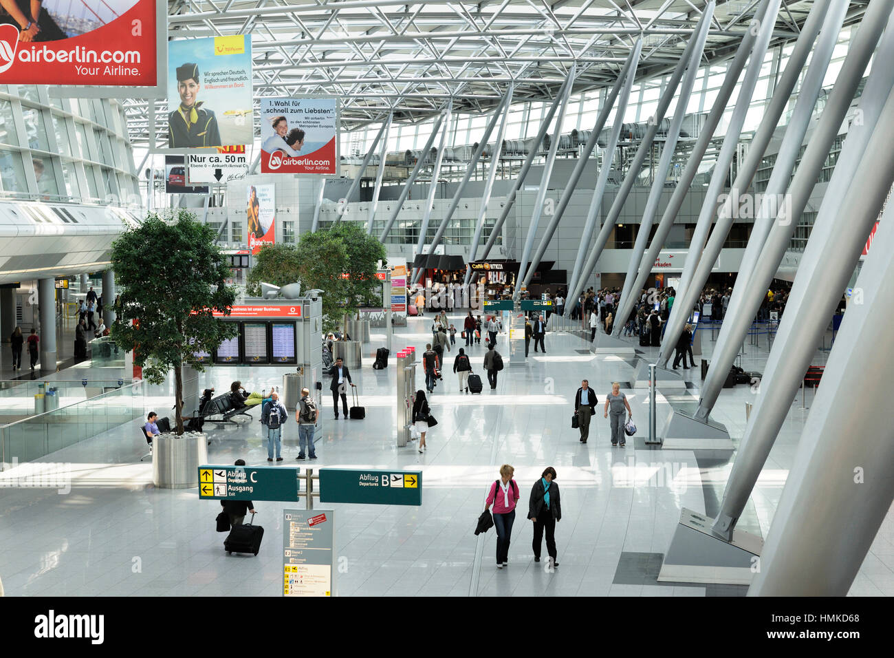 passengers with bags walking in the terminal, ceiling structures and ...