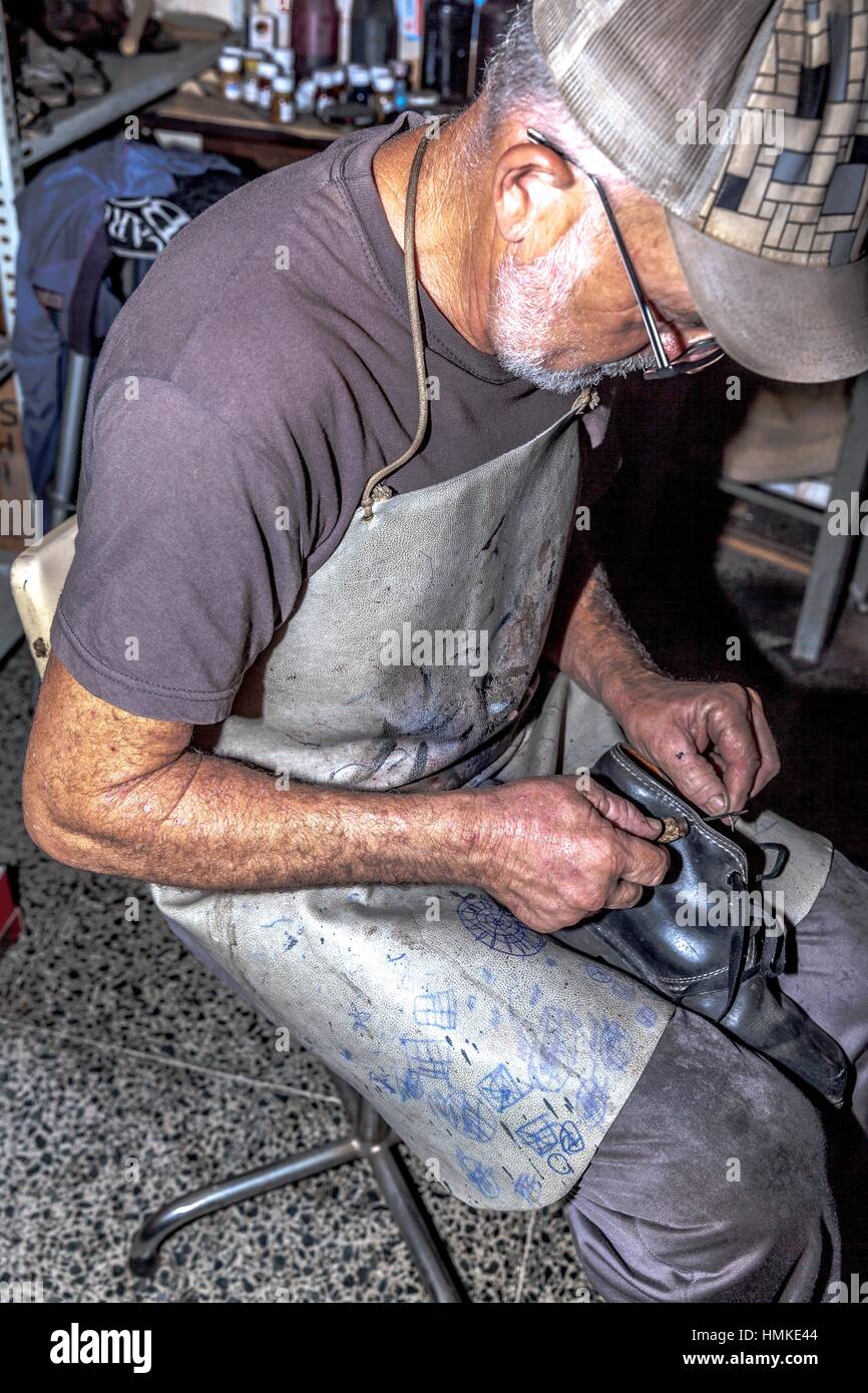 adult male shoemender working at his own workshop Stock Photo - Alamy