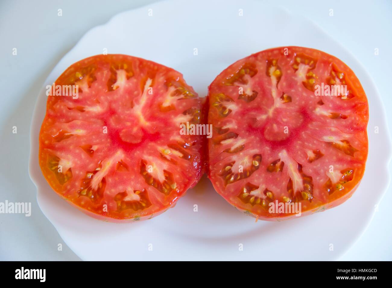 Tomato cut in two halves in a dish Stock Photo - Alamy