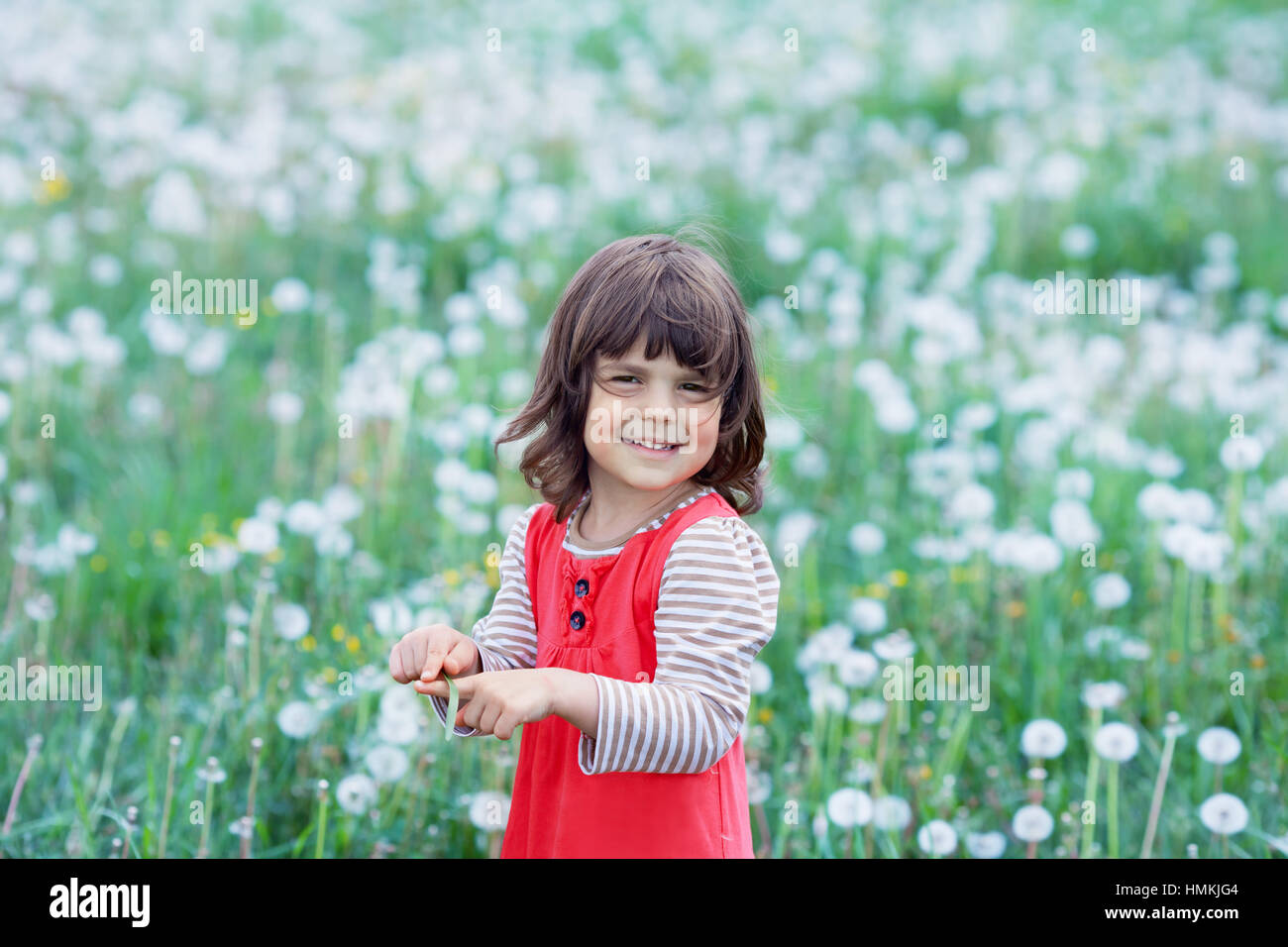 Little happy girl on the flower field Stock Photo - Alamy