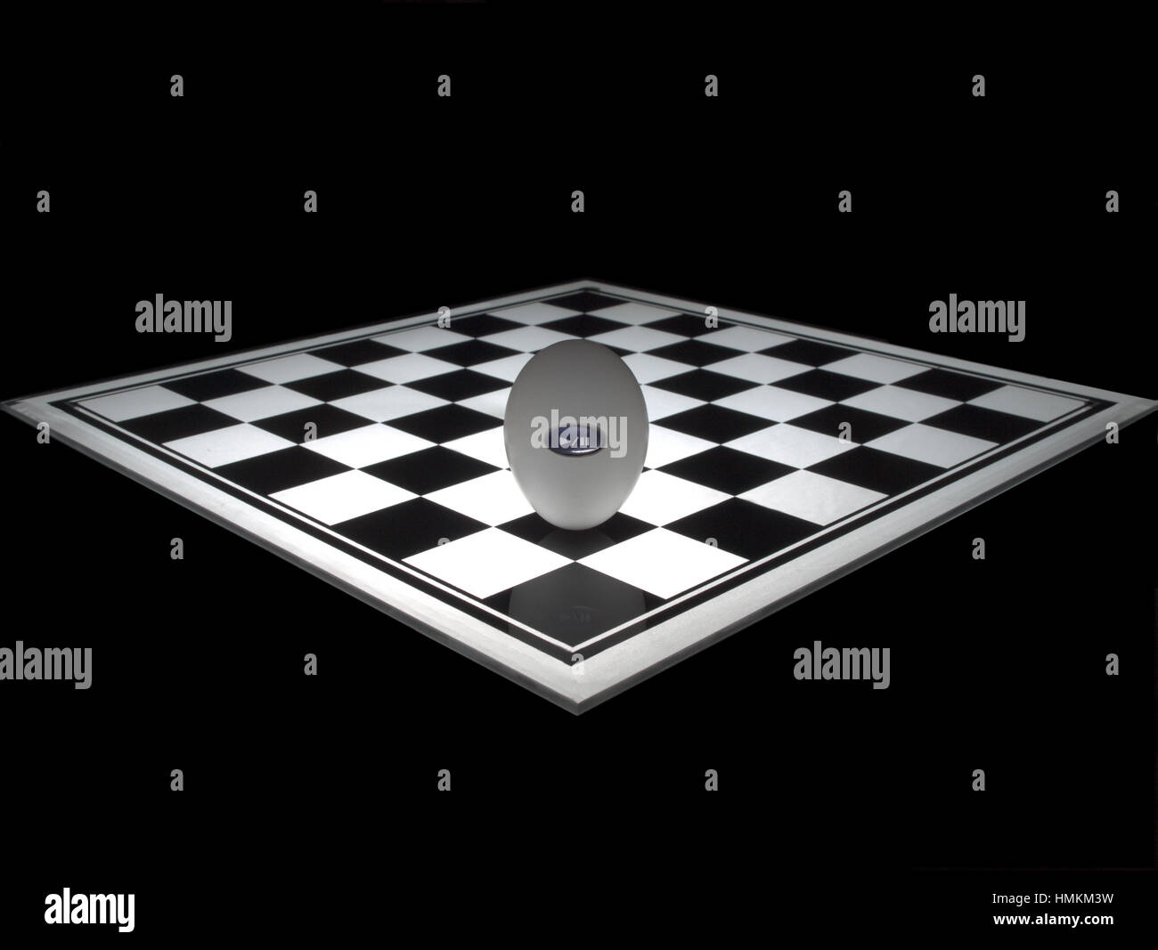 Egg with the start pause button standing on the chessboard, turned on ...