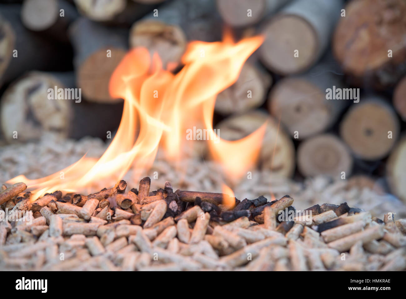 Fir pellets inflames in front wooden wall Stock Photo - Alamy