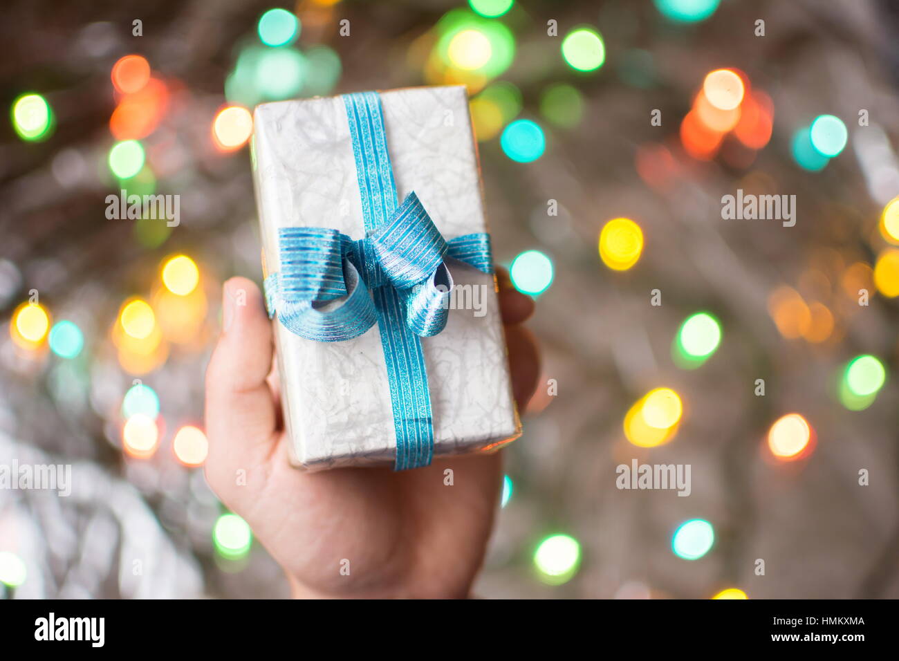 Male hand holding a present box with colorful background Stock Photo ...