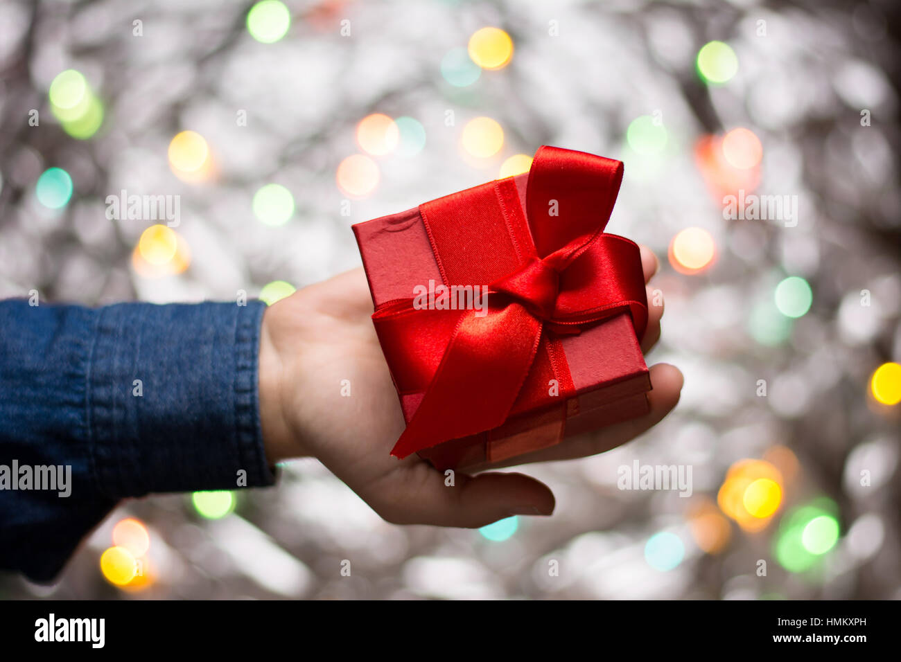 Male hand holding a red present with colorful background Stock Photo ...