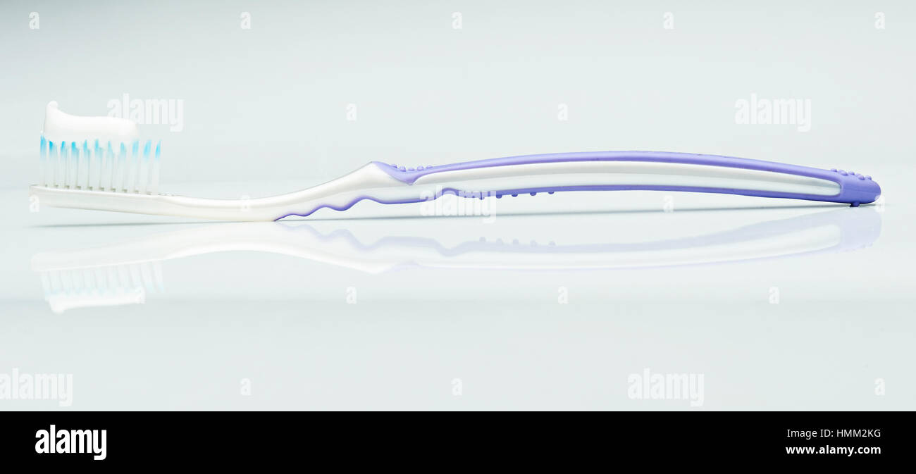 one purple tooth brush with white paste isolated Stock Photo - Alamy