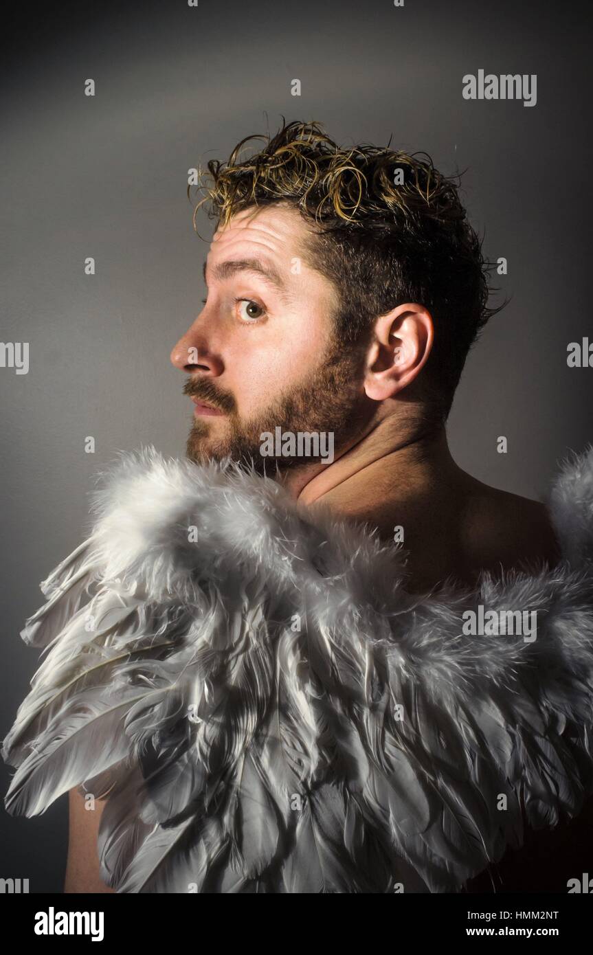 Bearded angel with feathered wings and dramatic lighting Stock Photo ...