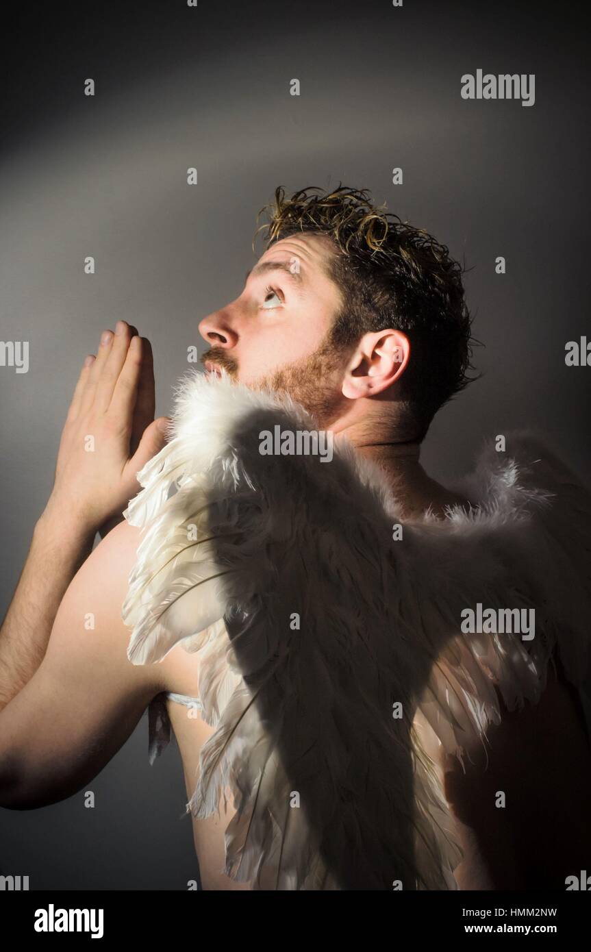 Bearded angel with feathered wings and dramatic lighting Stock Photo ...