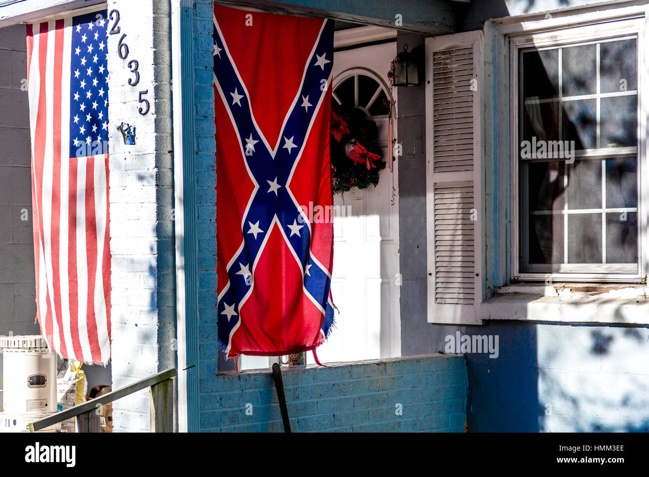 Confederate flag displayed with US Flag on front porch near window ...