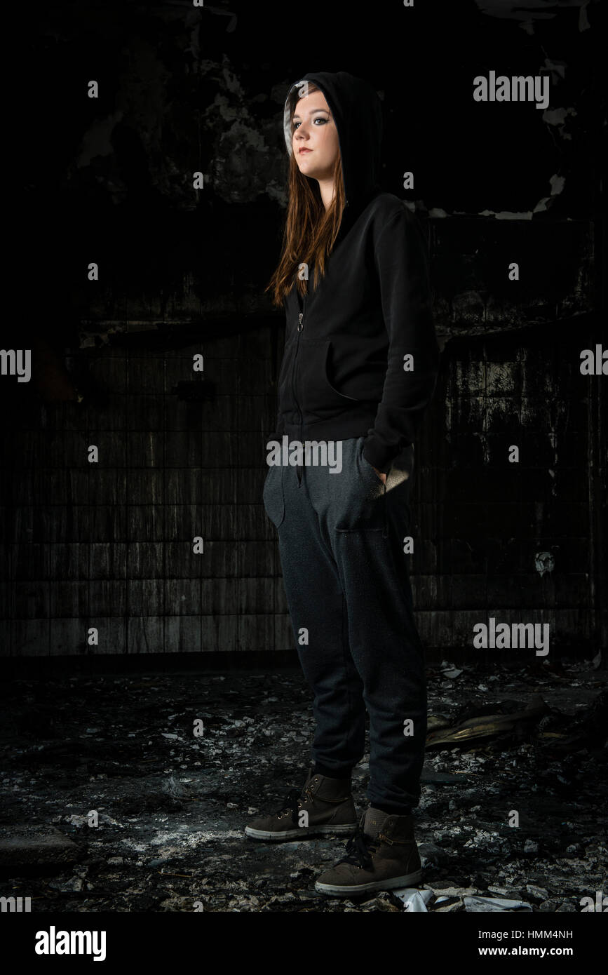 Portret of a young girl standing in a house what is destroyed by fire ...