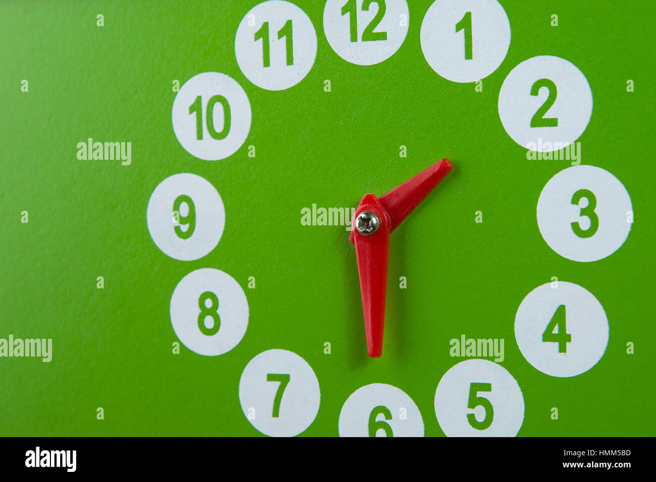 Toy clock on green background Stock Photo - Alamy