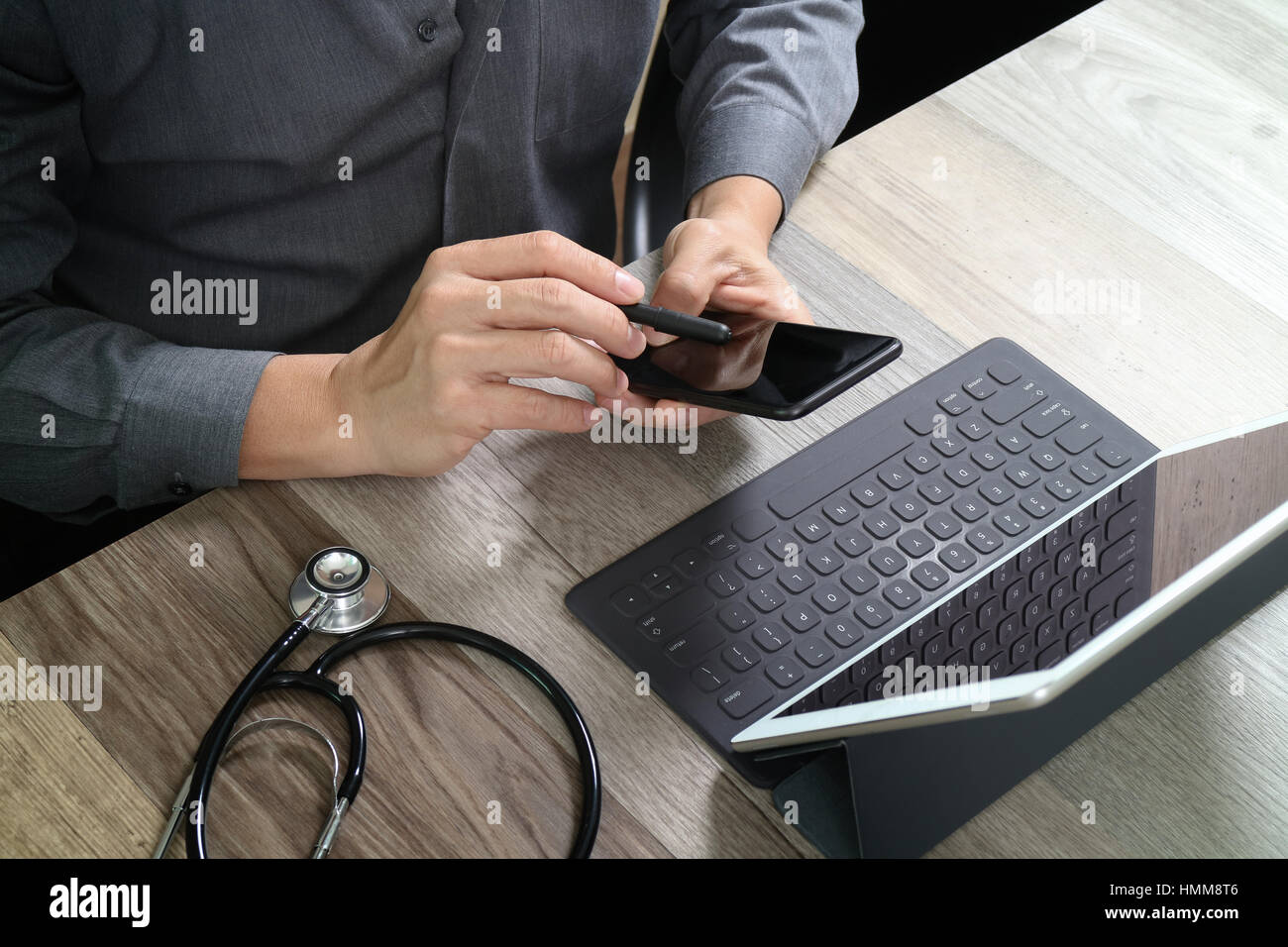 top view of medical doctor hand working with smart phone,digital tablet computer,stethoscope ...
