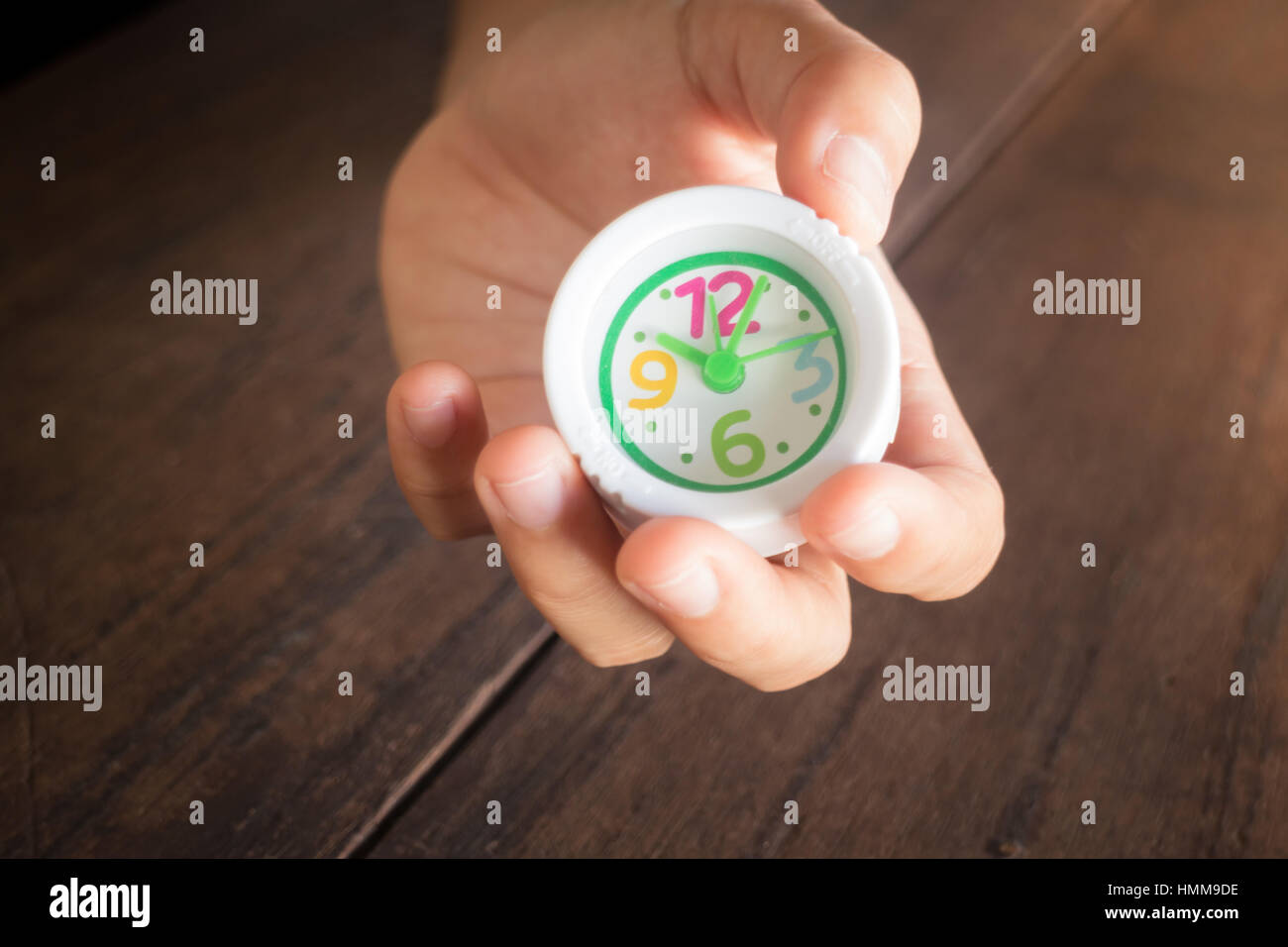 Mini white clock in hand, stock photo Stock Photo - Alamy