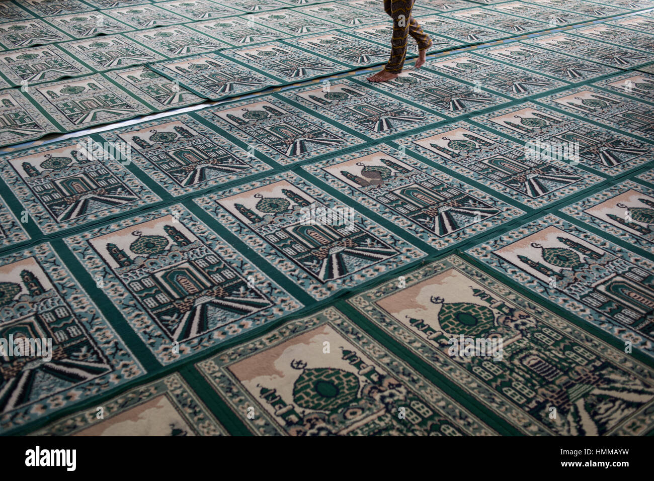 A person walks on top of Muslim praying carpets inside the Grand Mosque ...