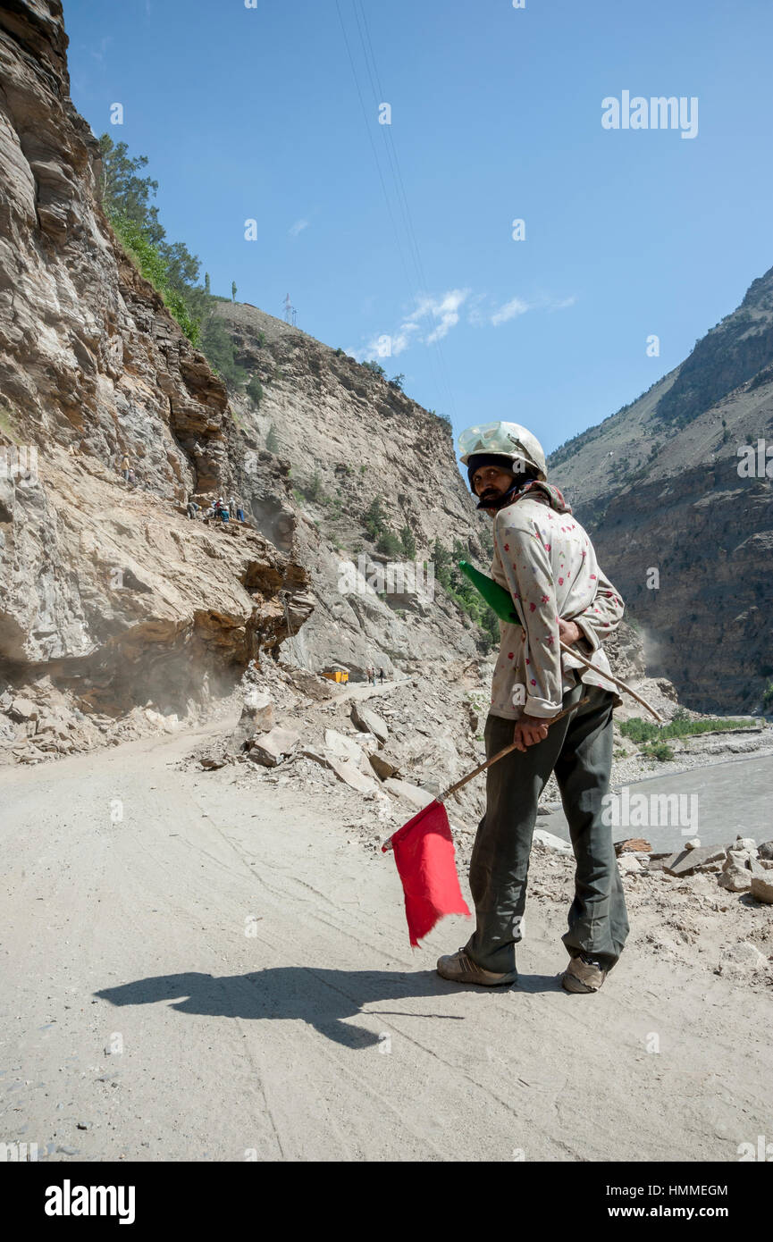 Indian man with rad flag blocking the way as civil work are ongoing to ...